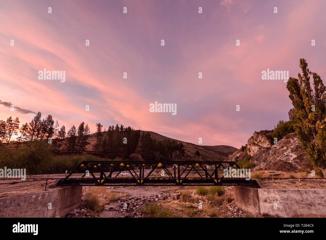 Railroad bridge under pink sky during sunset Stock Photo - Alamy