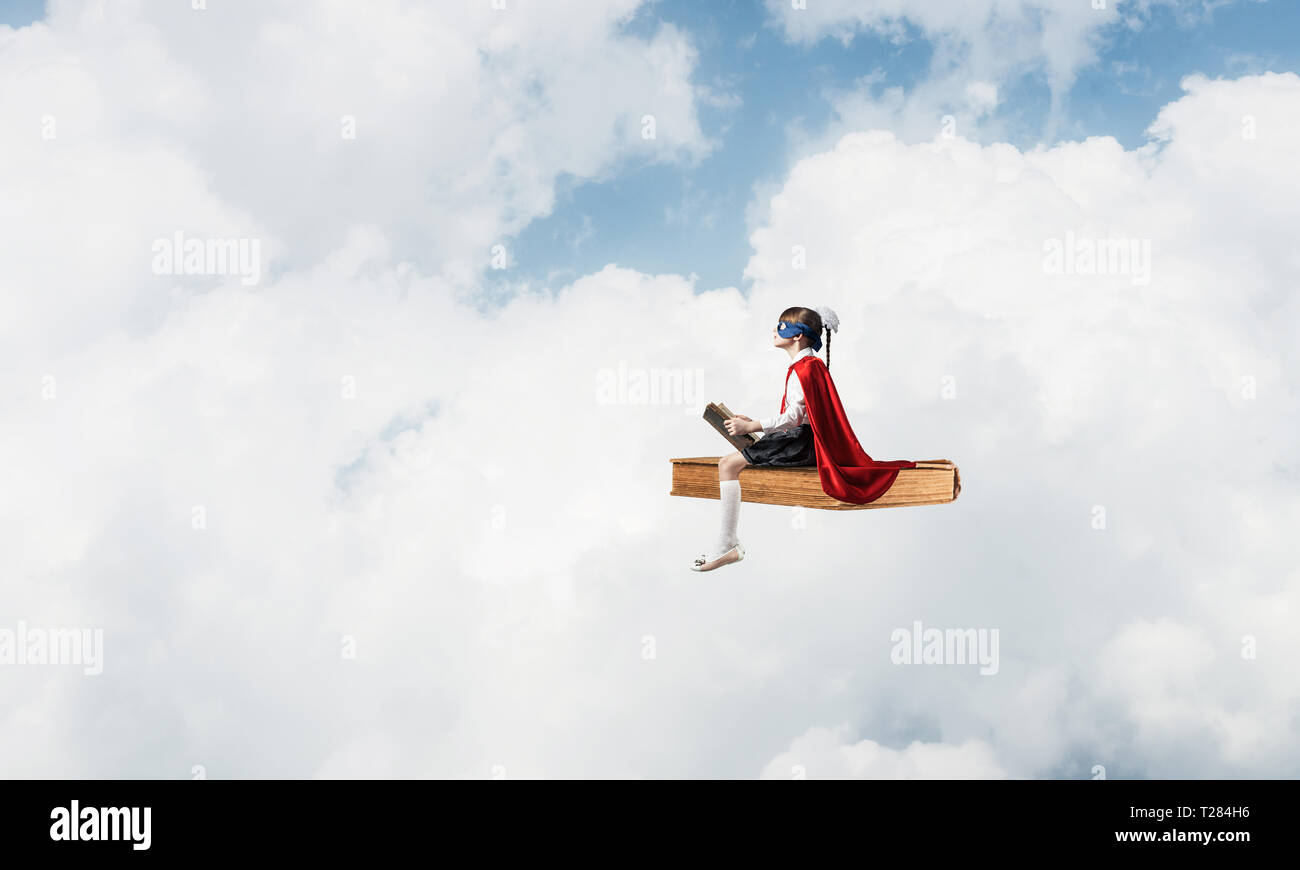 Girl power concept with cute kid guardian against cloudscape background ...