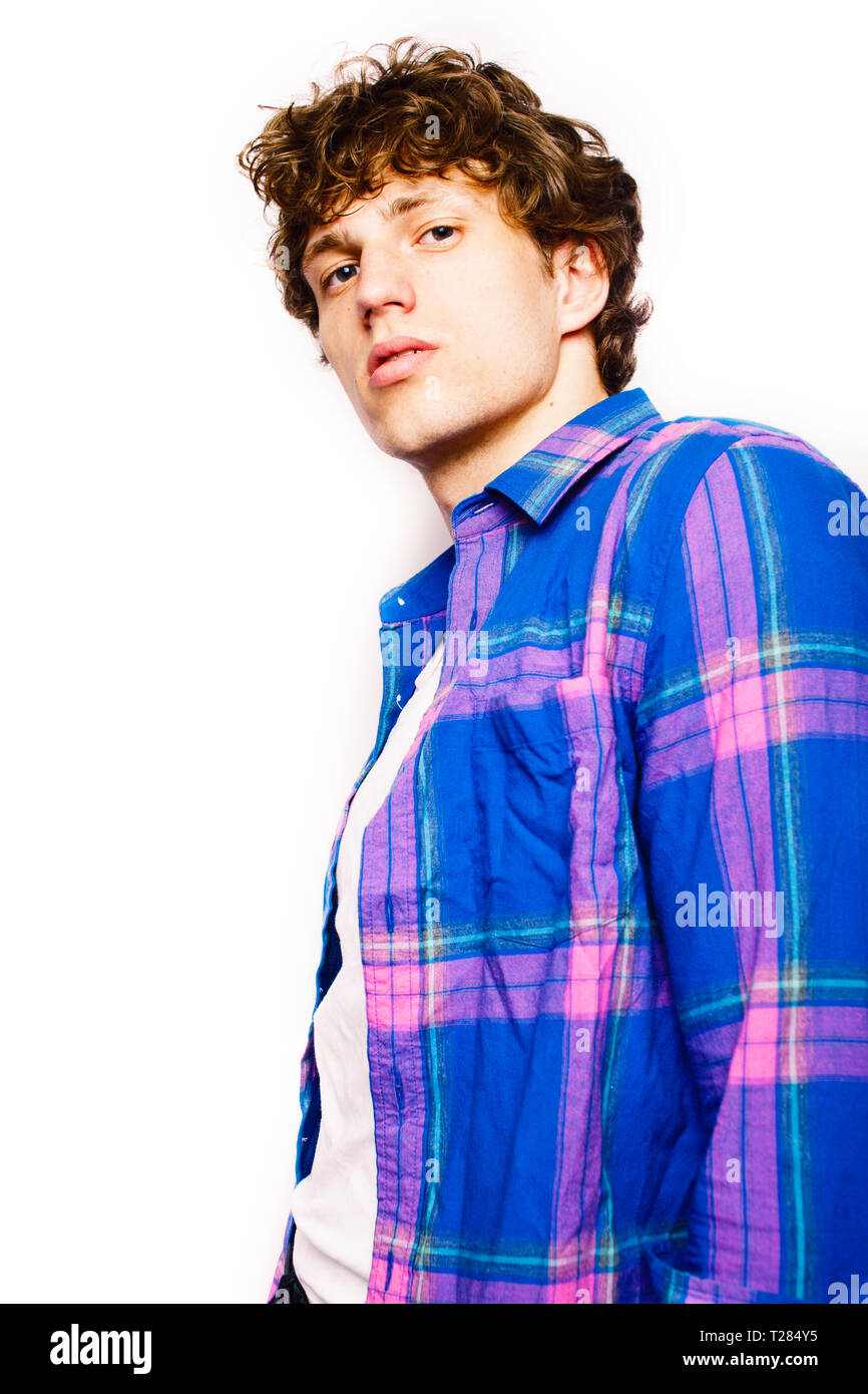 Portrait of a smart serious young man standing against white background ...