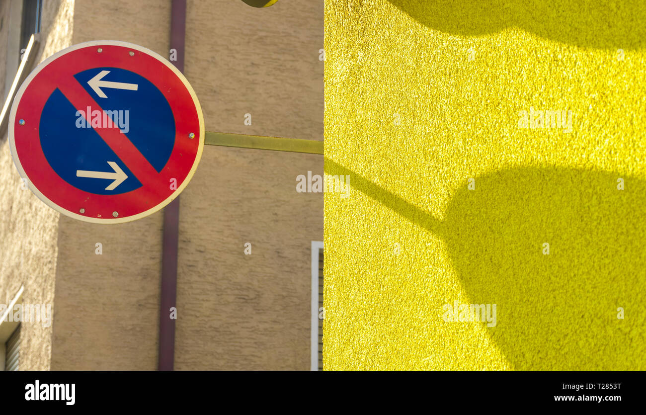 Road sign on a yellow house wall background Stock Photo - Alamy