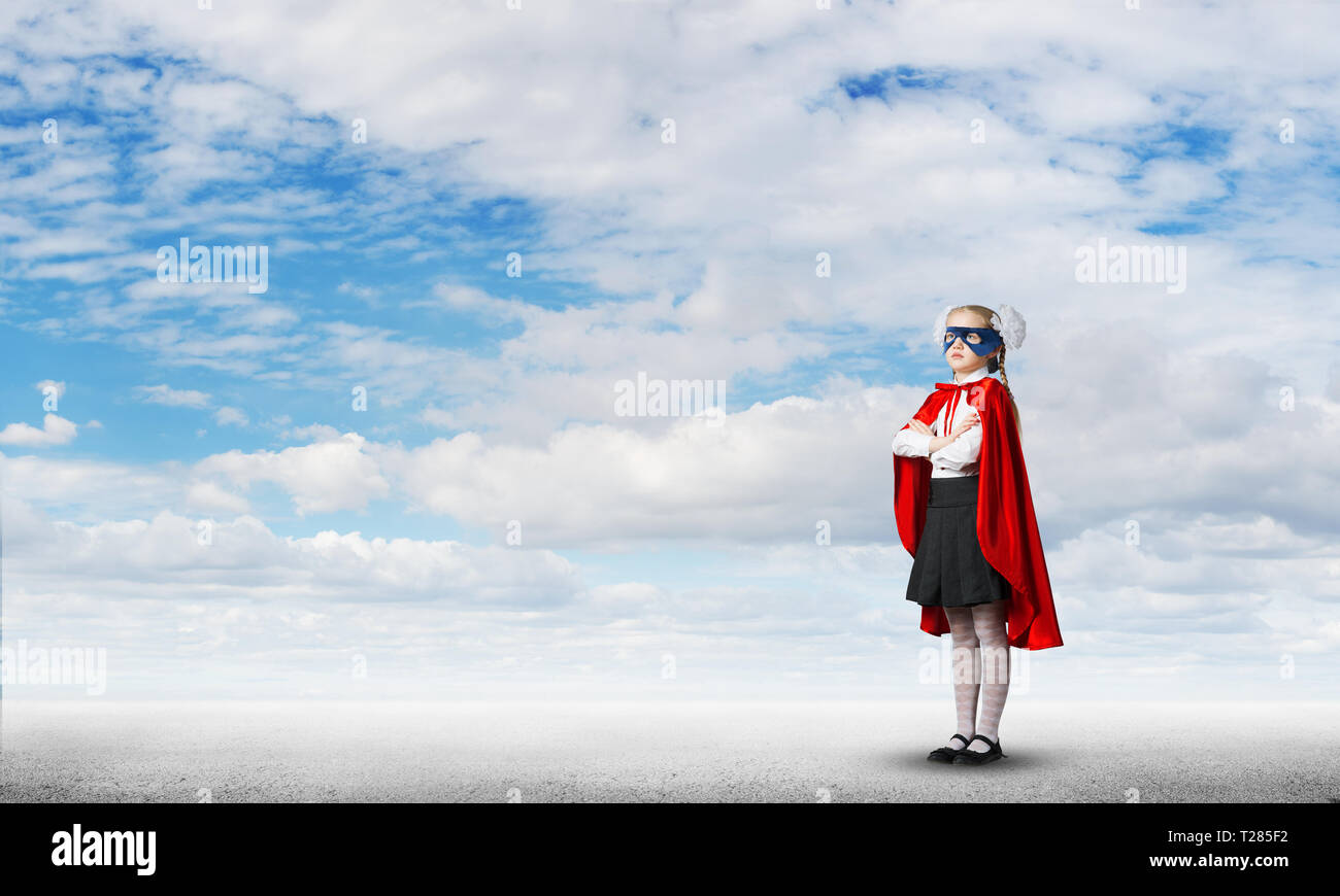 Girl power concept with cute kid guardian against cloudscape background ...