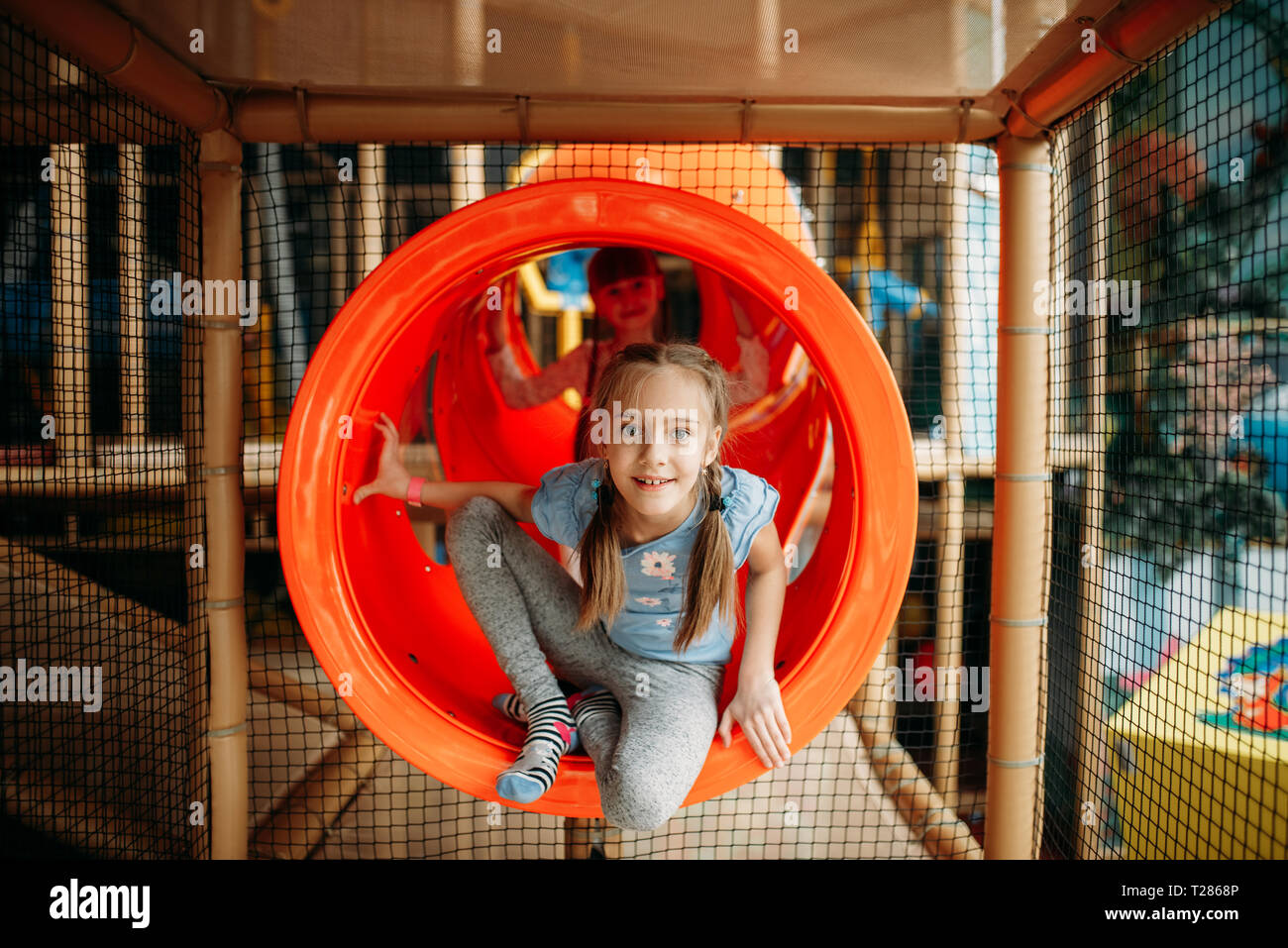 Two little girls climbing the maze in children game center. Excited ...