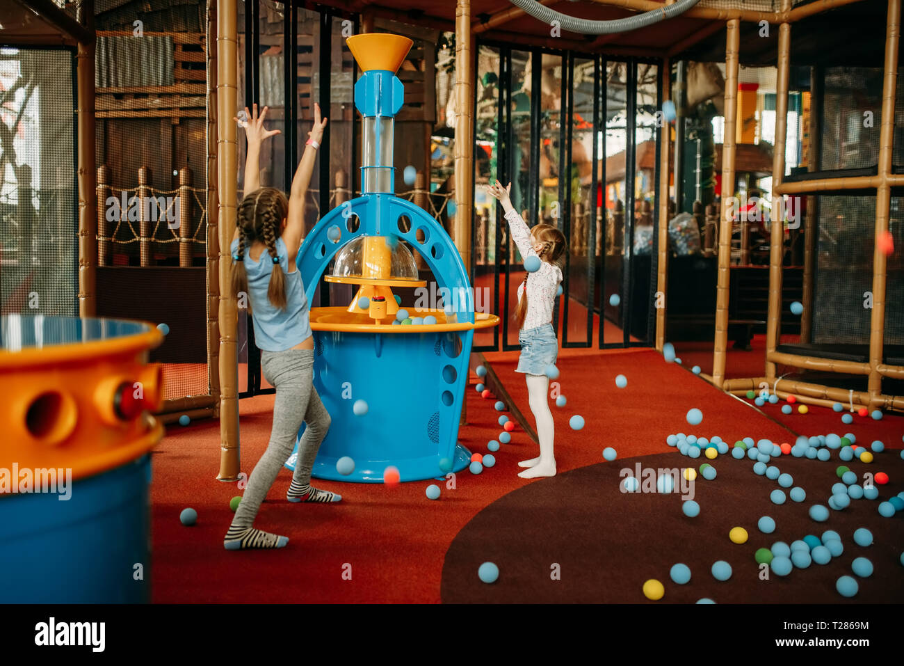 Two little girls plays air gun machine in children game center. Excited ...