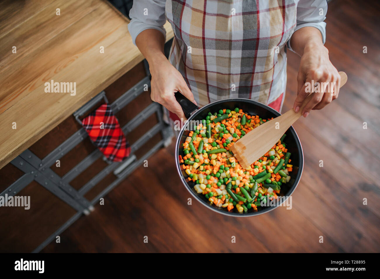 Close up of woman's hands holding frying pan with food in it. She stand ...