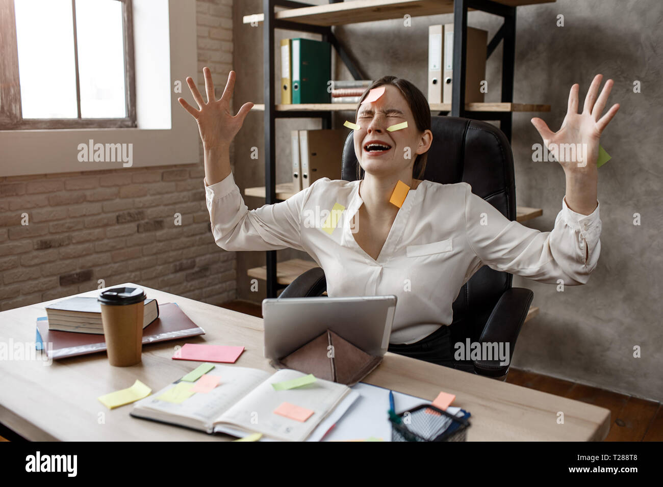 Young businesswoman have panic attack from multitasking. She has lots ...