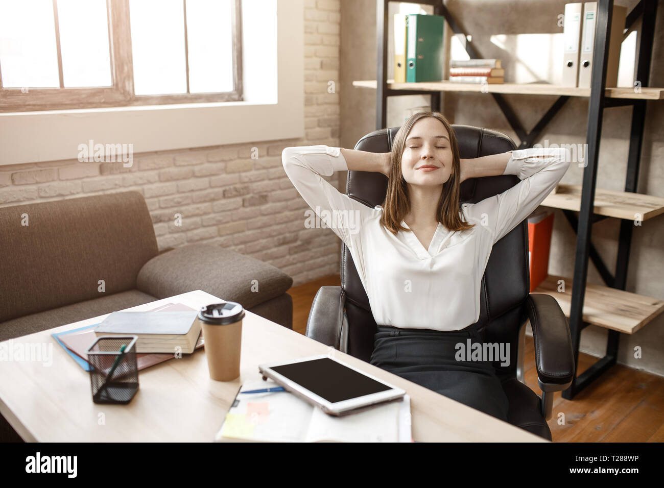 Young woman having rest. She sit at table in room with closed eyes ...