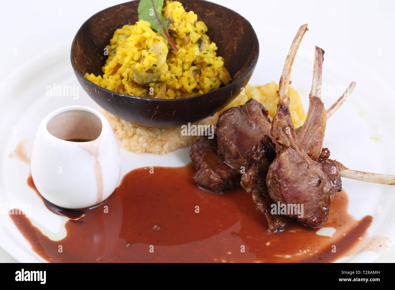 Rack of lamb with rice on a white background Stock Photo - Alamy