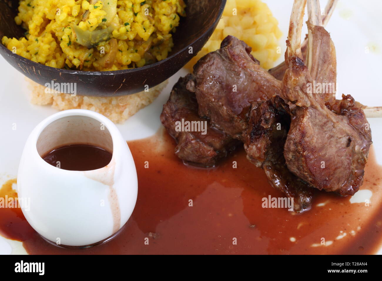 Rack of lamb with rice on a white background Stock Photo - Alamy