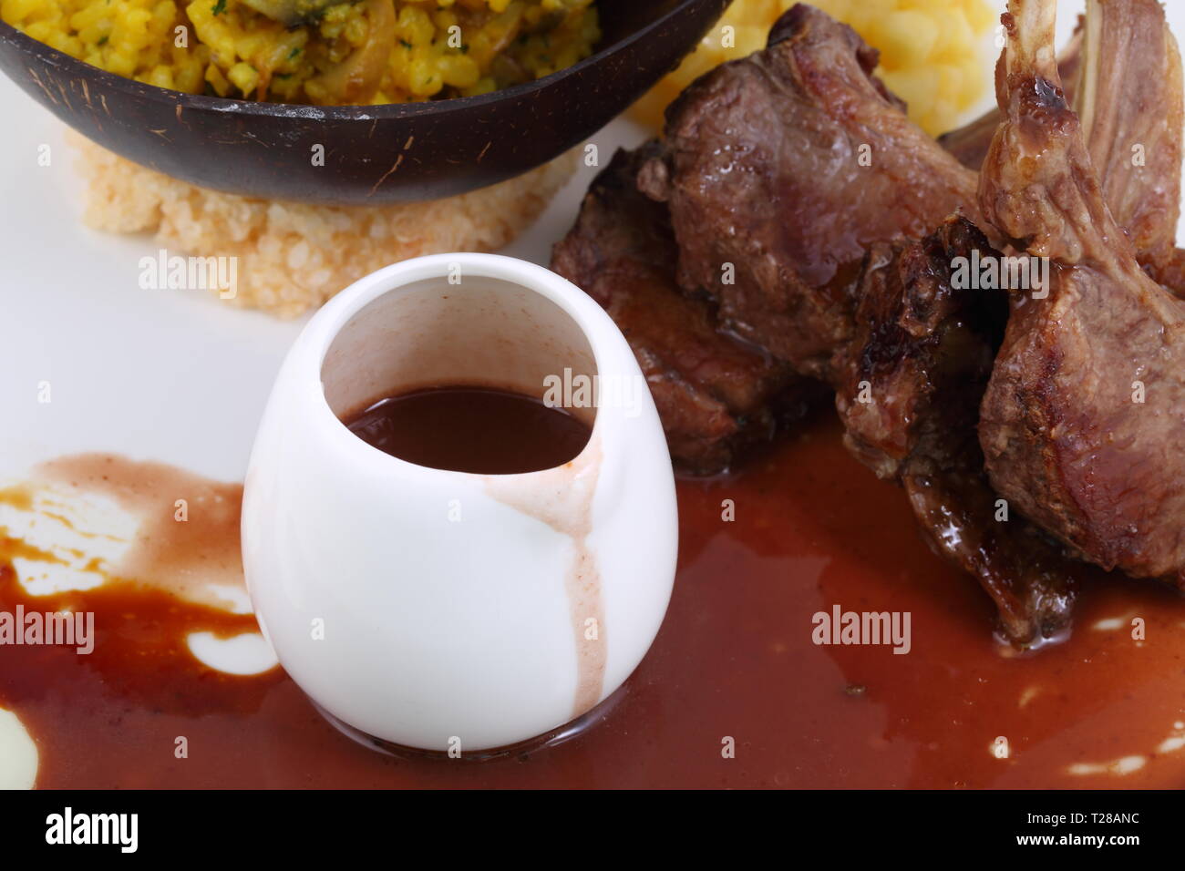 Rack of lamb with rice on a white background Stock Photo - Alamy