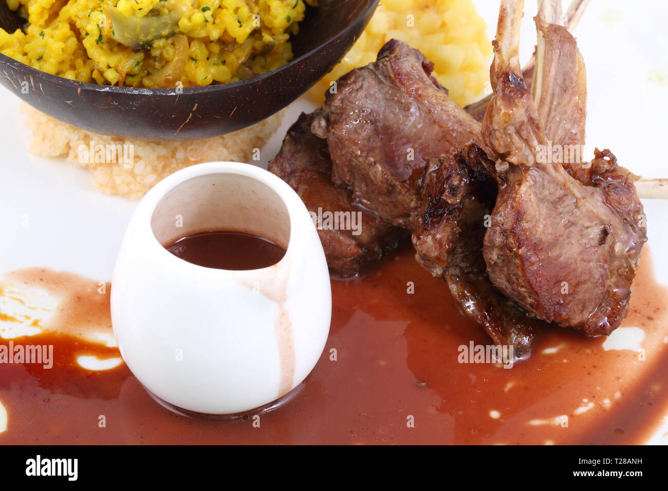 Rack of lamb with rice on a white background Stock Photo - Alamy