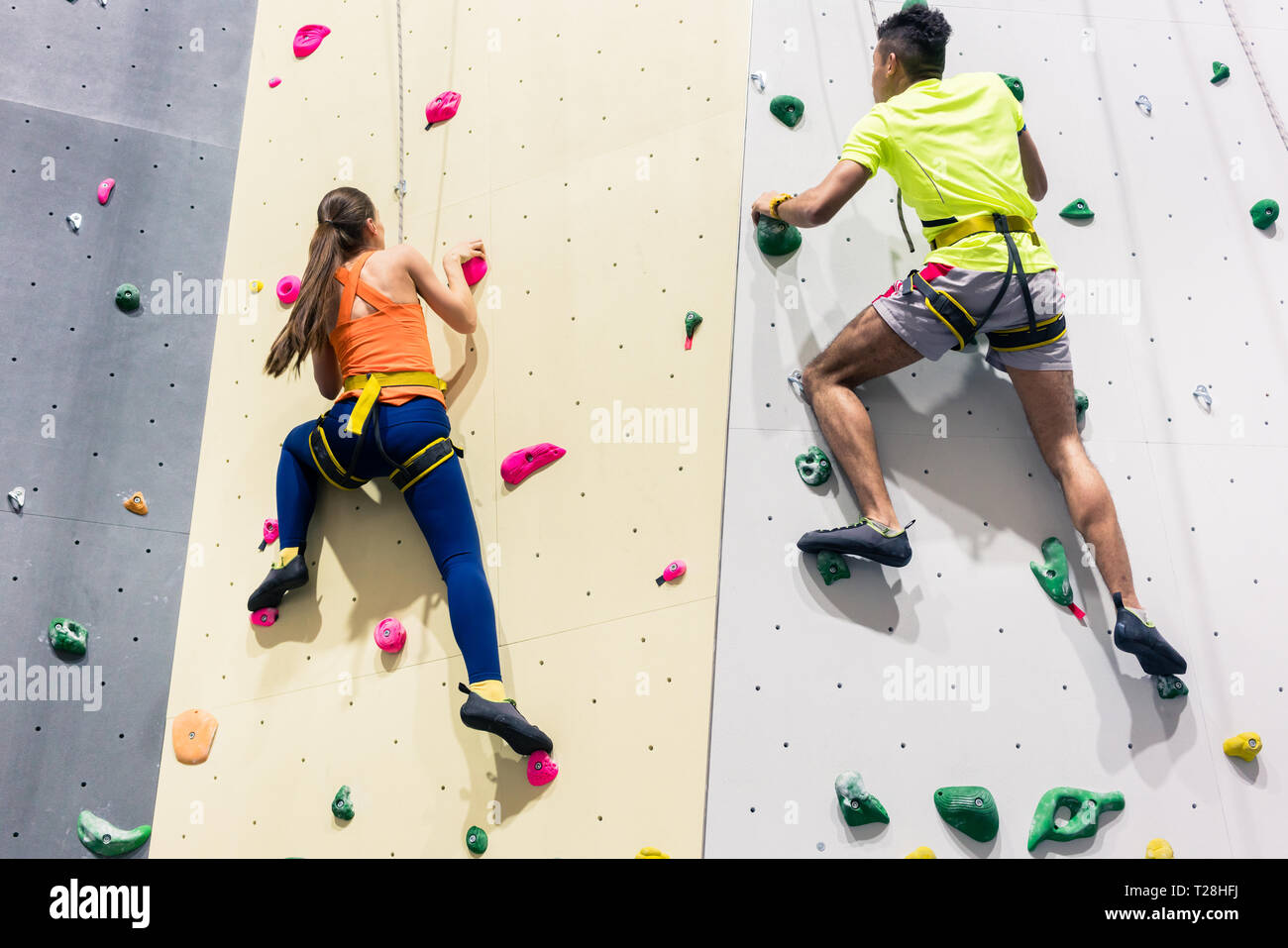 Sporty people climbing wall Stock Photo - Alamy