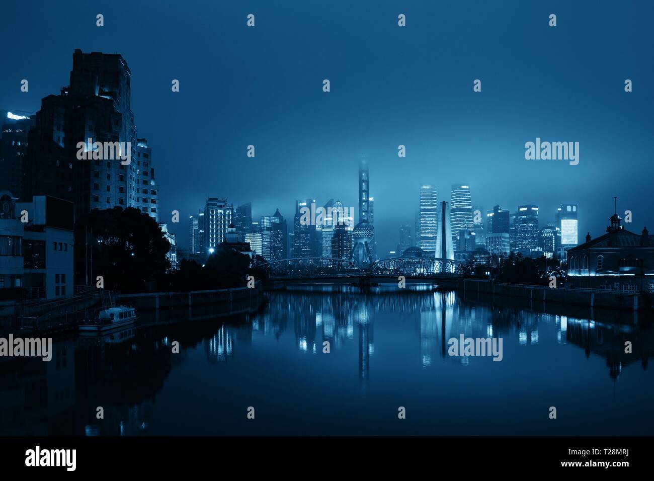 Shanghai city night view with skyscrapers and water reflections in ...