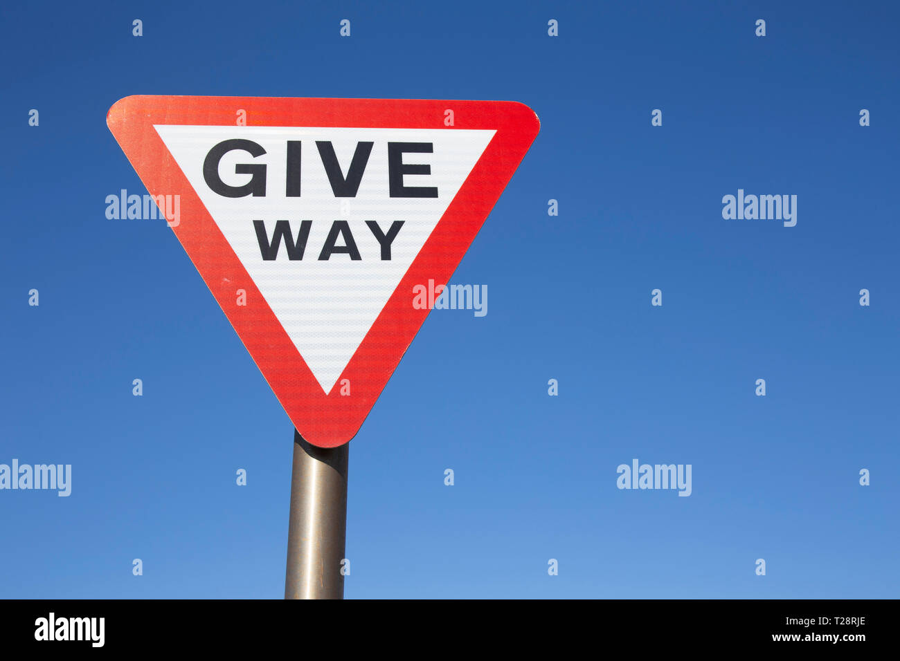 Give Way sign against blue sky Stock Photo - Alamy