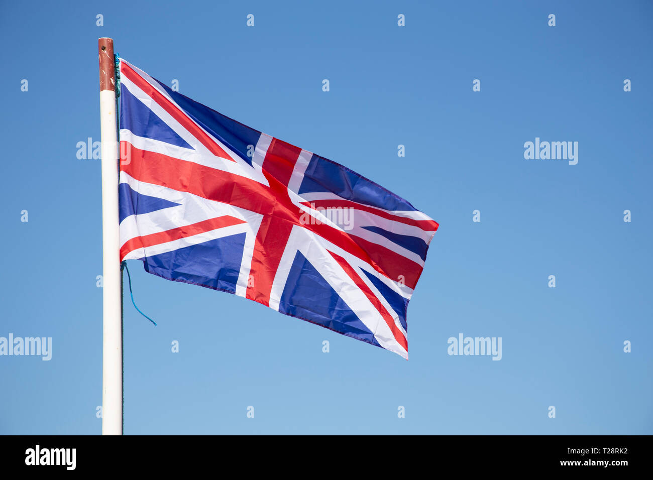 Union Jack flag against a blue sky Stock Photo - Alamy
