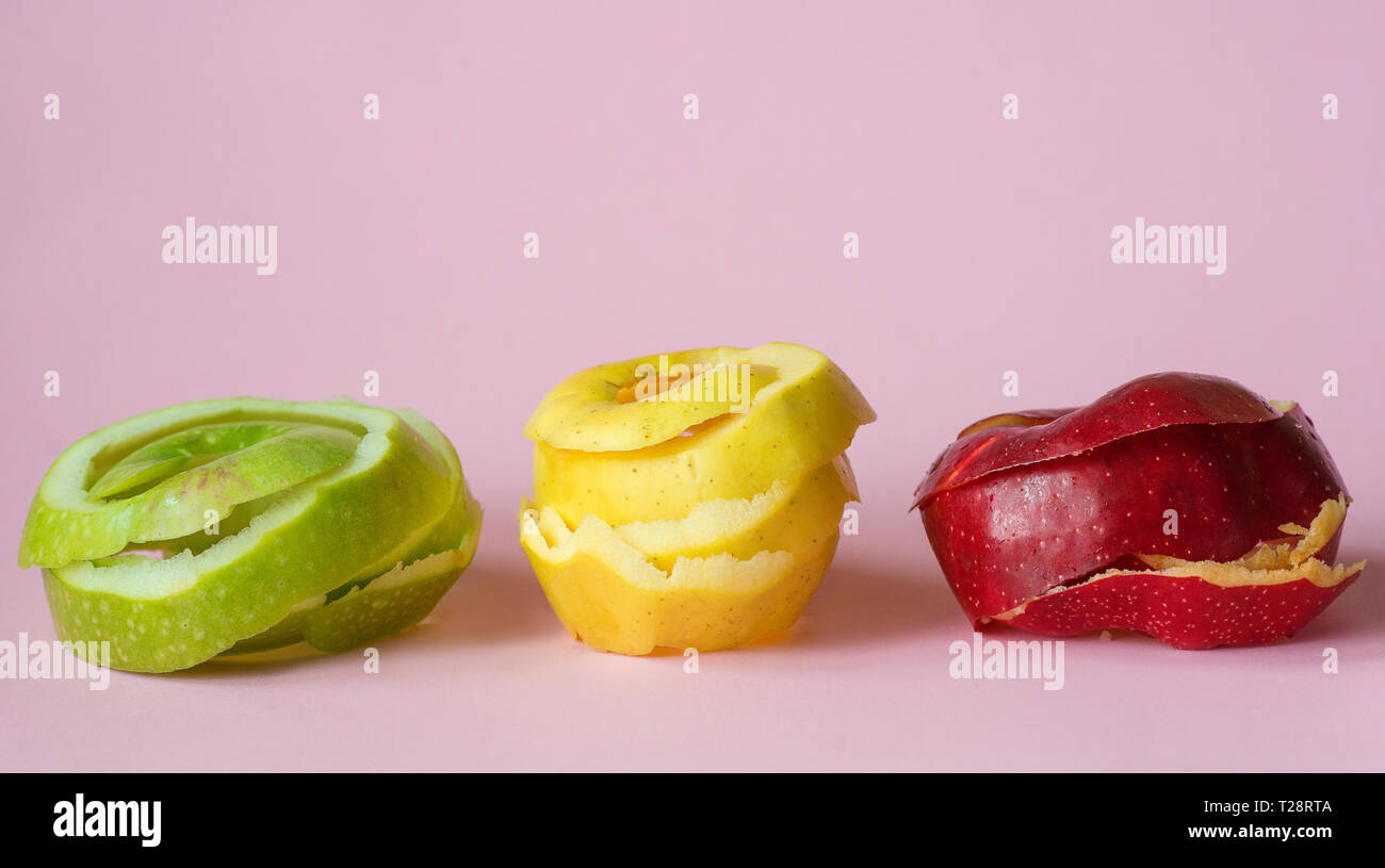 red, green, yellow apple peels on pink background as a symbol of ...