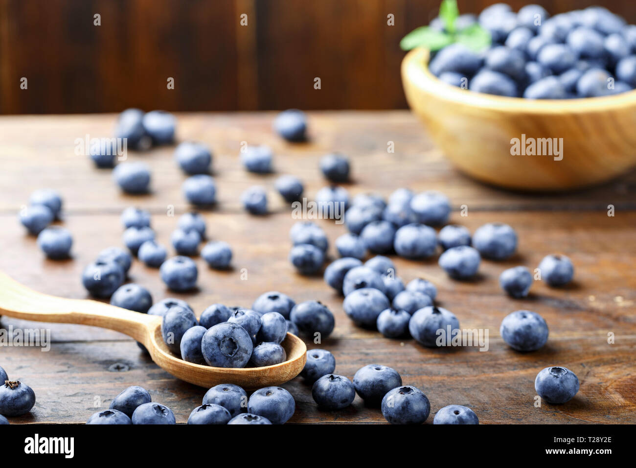 raw blueberries on a brown wooden table. space for text Stock Photo - Alamy