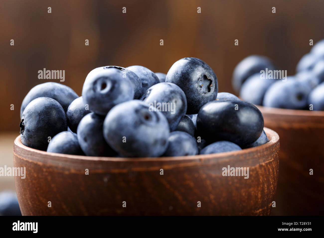 raw blueberries on a brown wooden table. space for text Stock Photo - Alamy