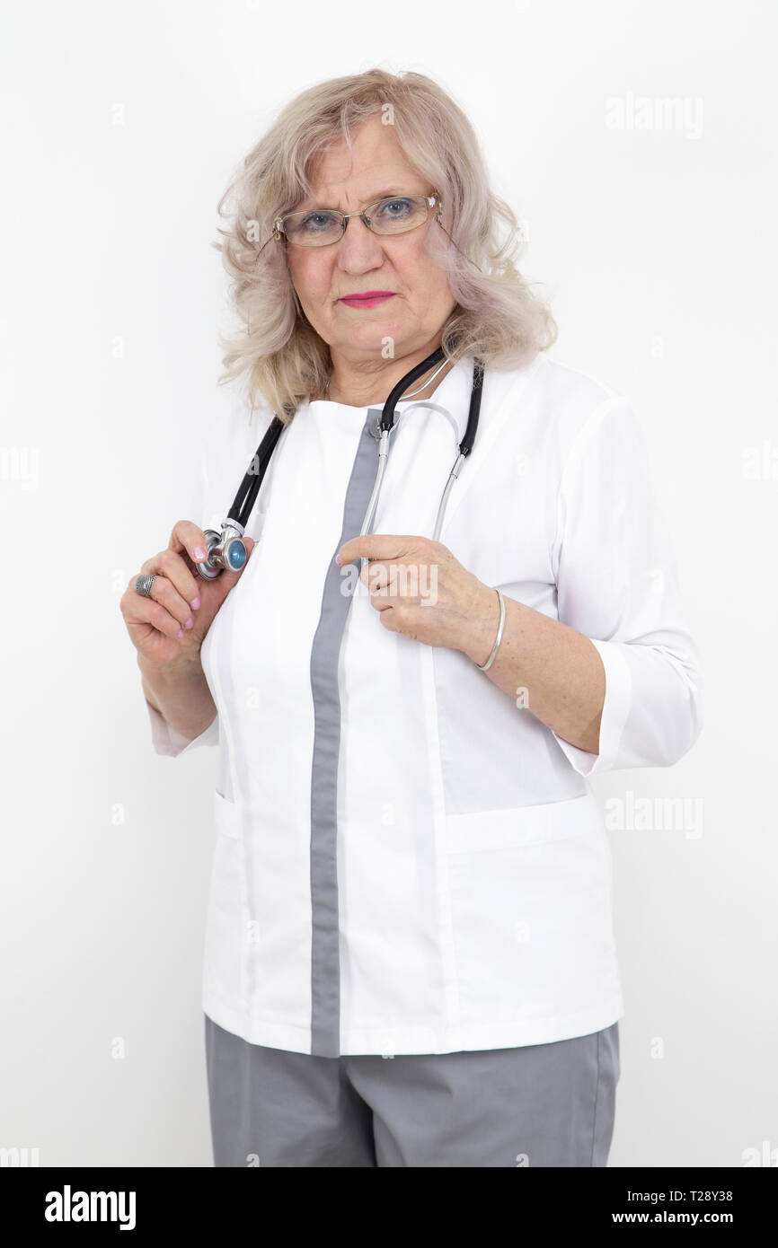 elderly female doctor with a stethoscope and in uniform against a white ...