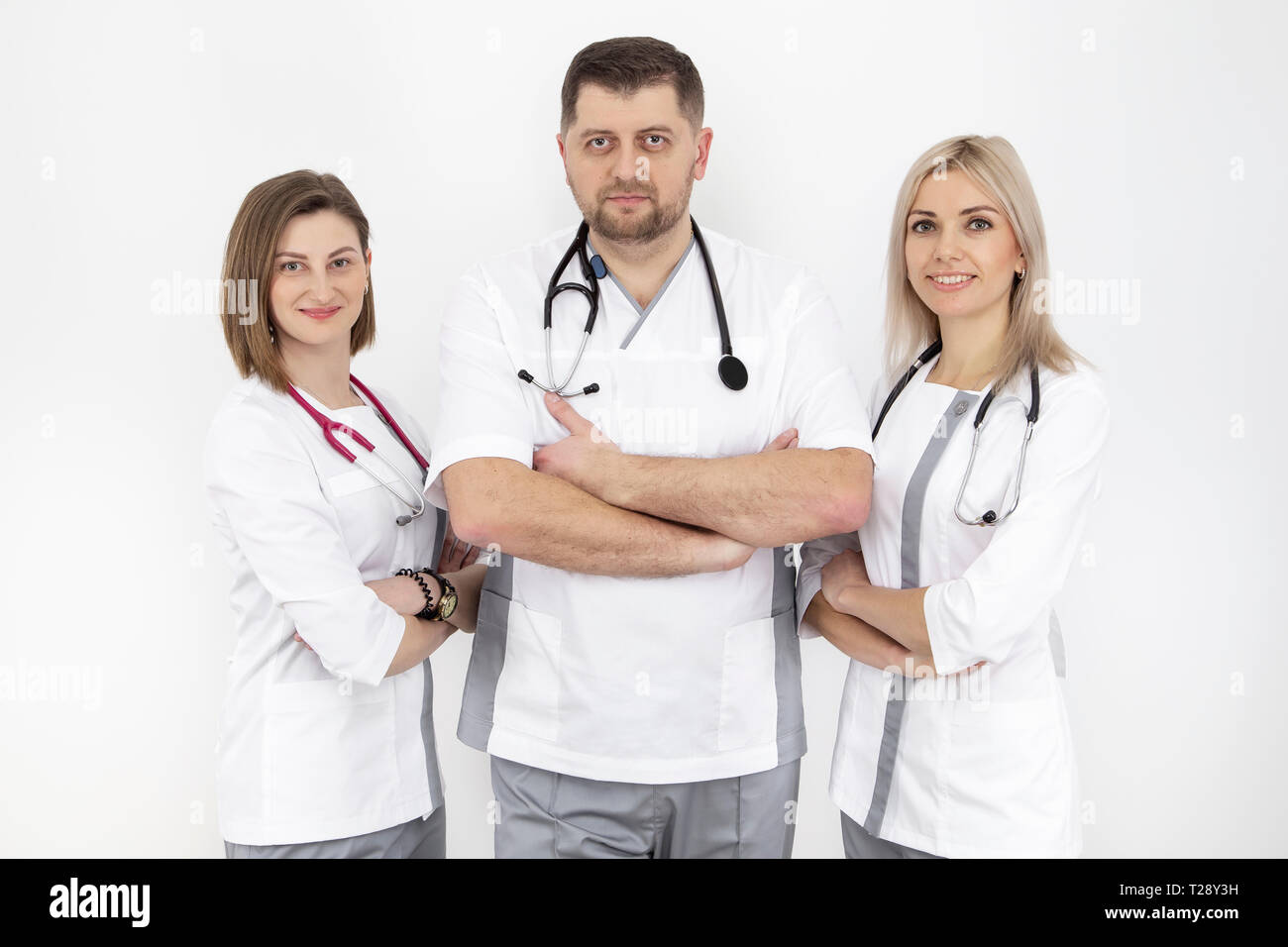 three doctors with a stethoscope are smiling. a man and two young girls ...