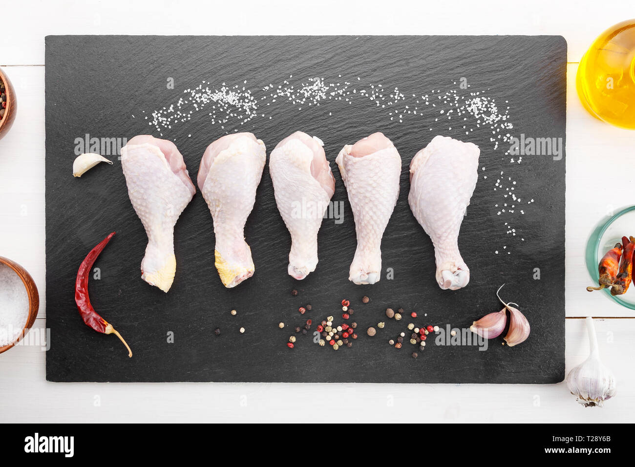 raw chicken legs with spice on a black slate background. view from ...