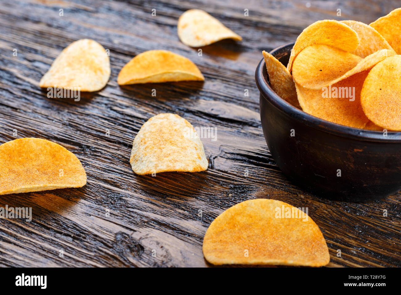 Crispy potato chips in a clay plate on old kitchen table Stock Photo ...
