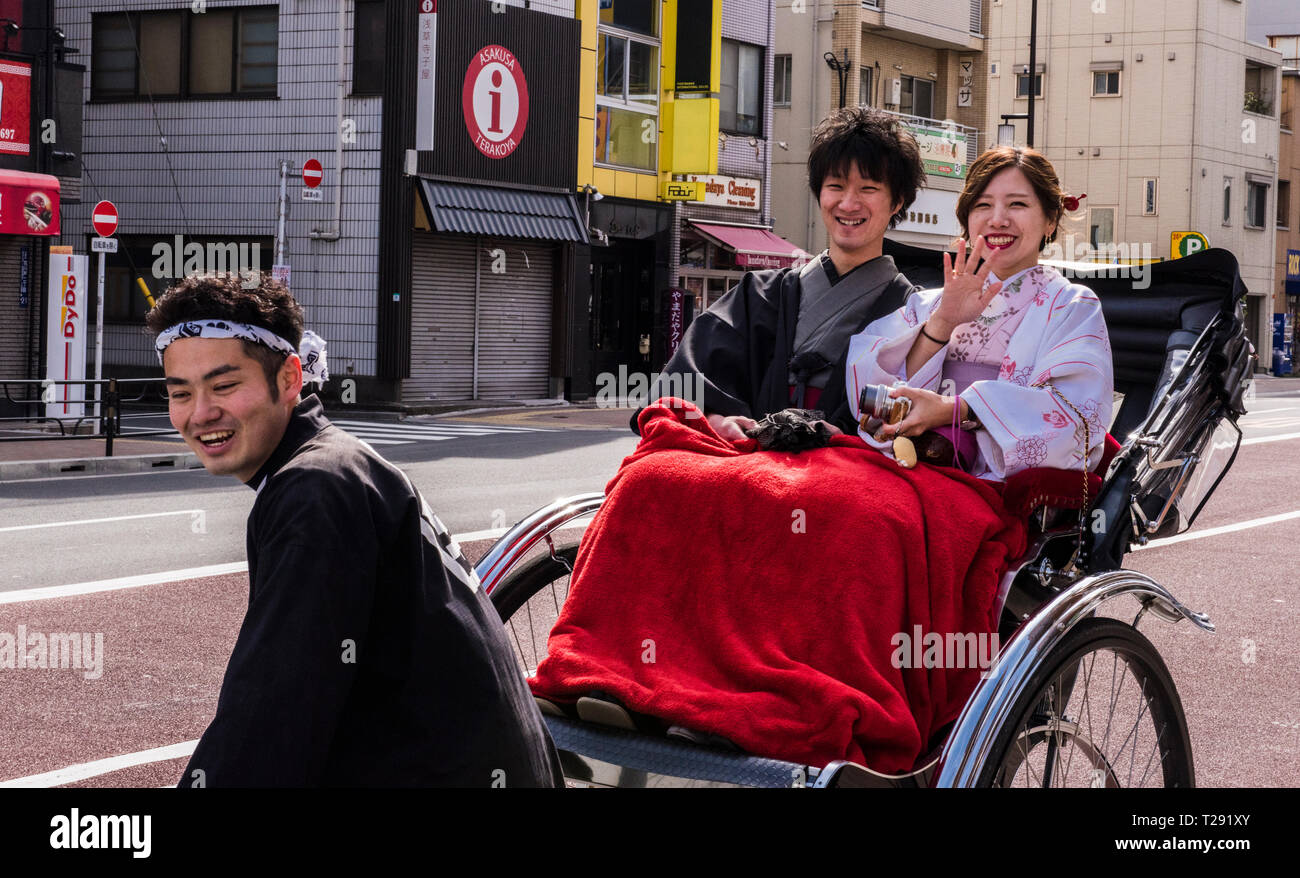 Man and woman in traditional clothing, taking rickshaw ride, smiling ...