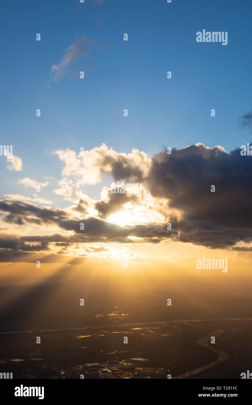 Beams of sun going through clouds onto evening land Stock Photo - Alamy
