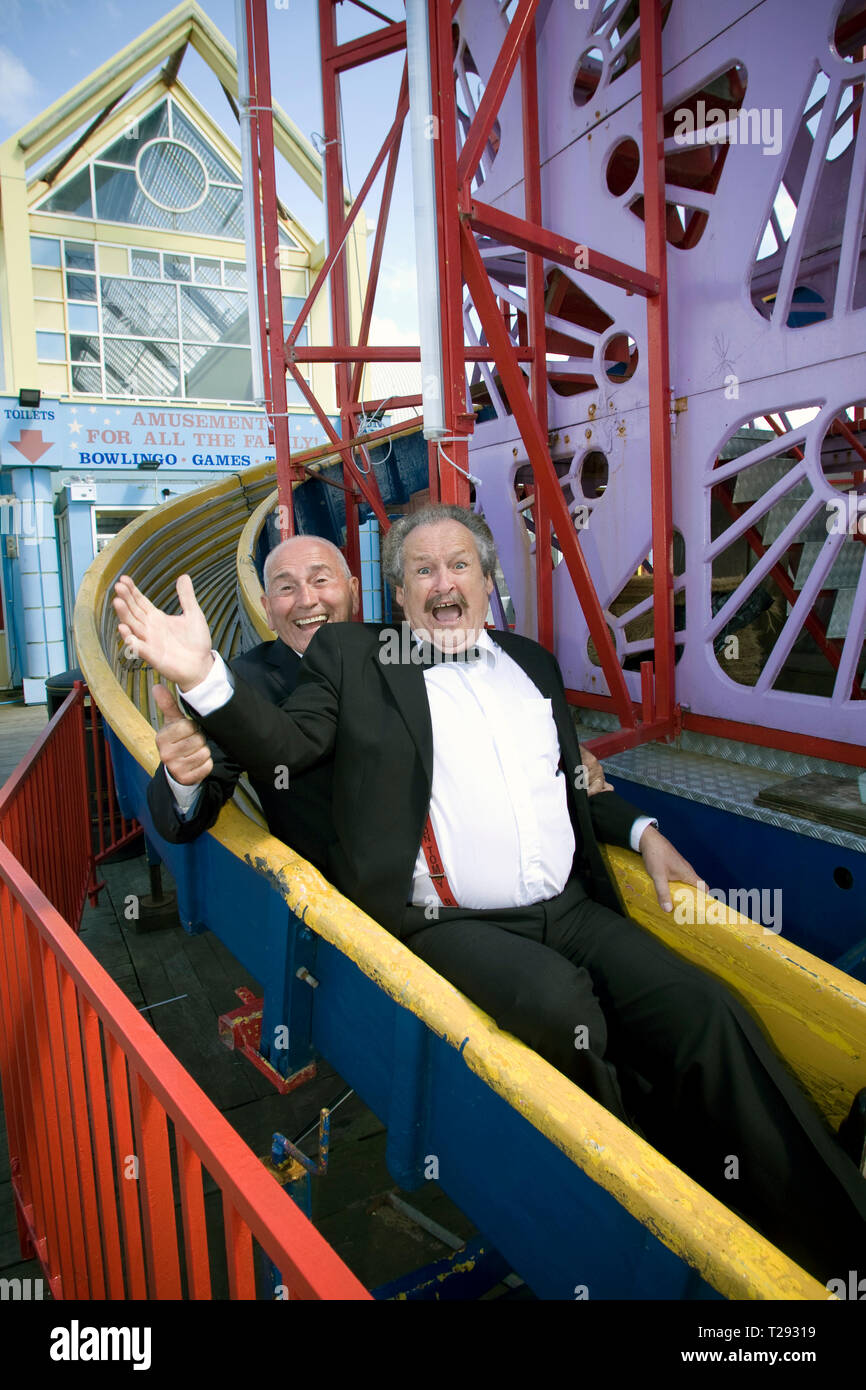 Comedians Tommy Cannon and Bobby Ball pictured on a fairground slide on ...