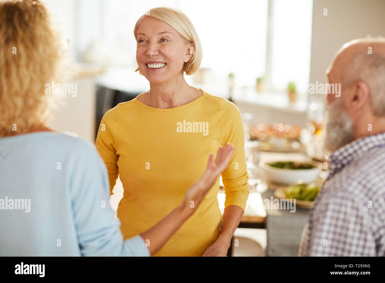 Smiling man welcoming friends hi-res stock photography and images - Alamy