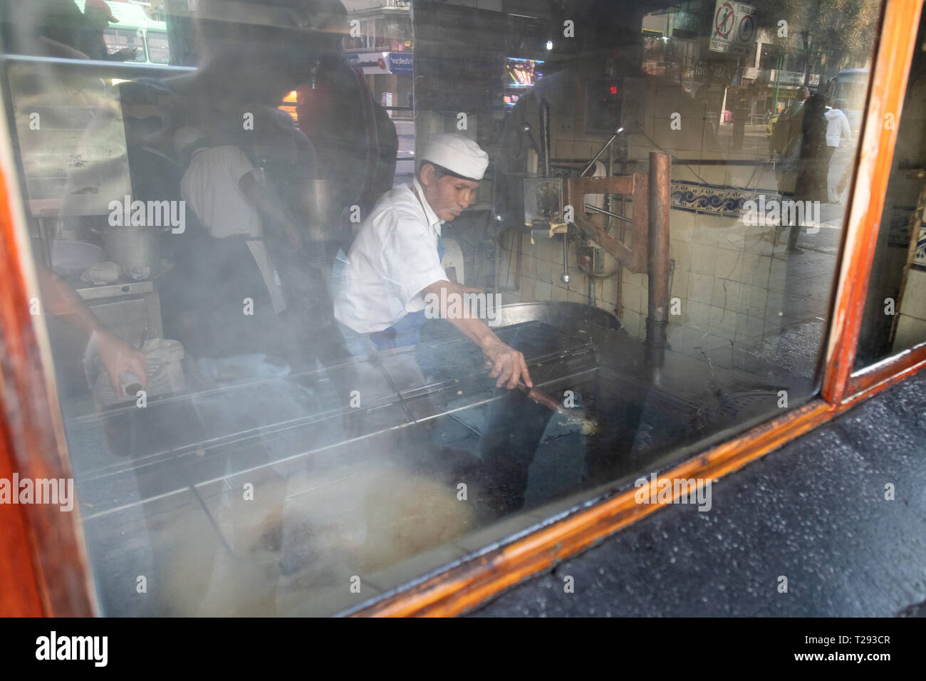 Man making traditional Mexican churros in the window of restaurant in ...