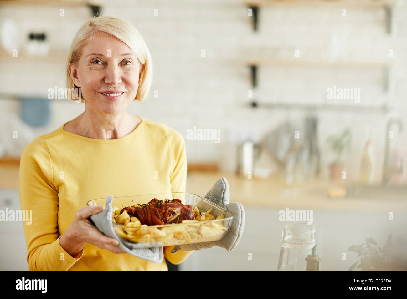 Careful mature lady with cooked meat Stock Photo - Alamy