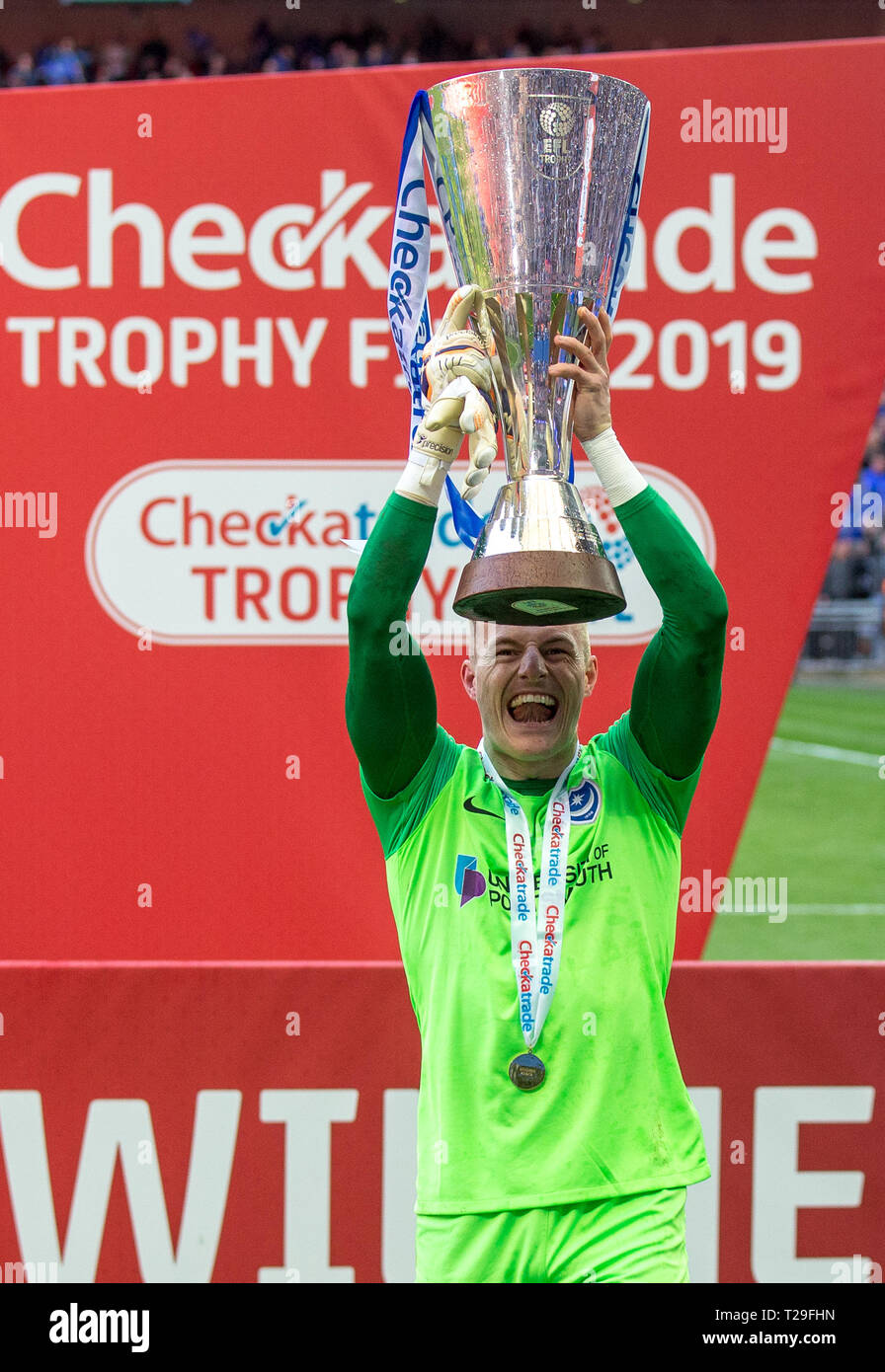Goalkeeper Craig MacGillivray of Portsmouth lifts the winning trophy ...