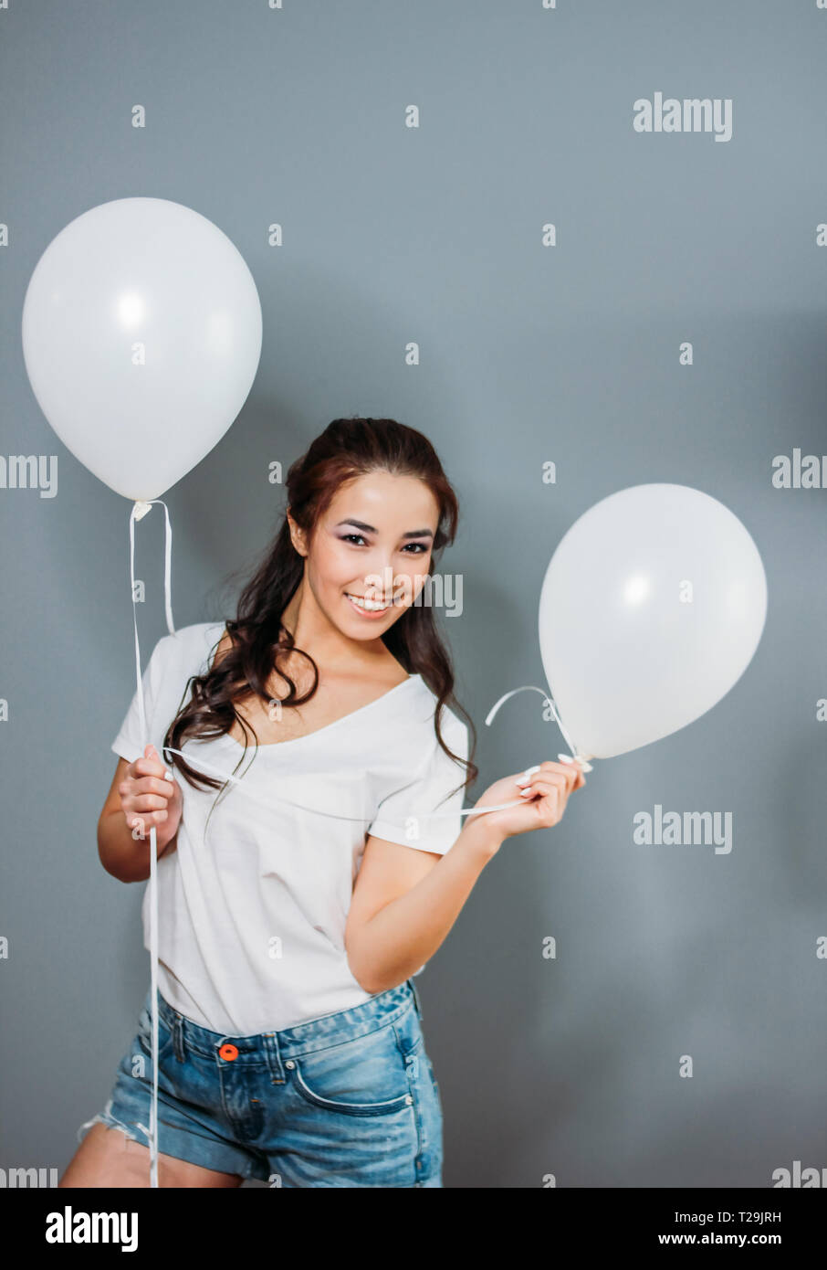 Beautiful smiling asian young woman with dark long hair with white ...