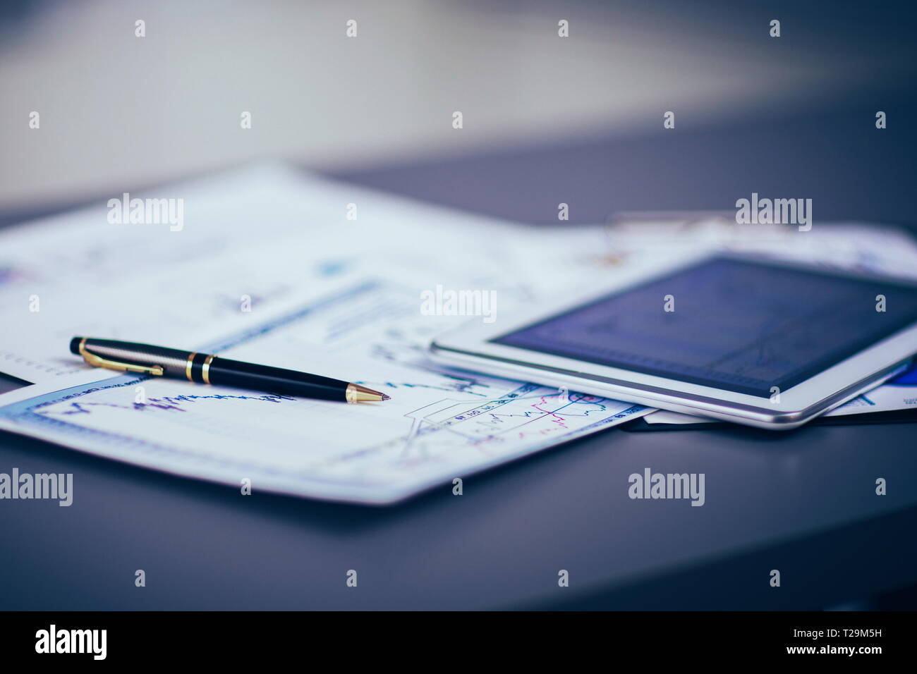 Tablet computer and financial diagrams in the workplace Stock Photo - Alamy