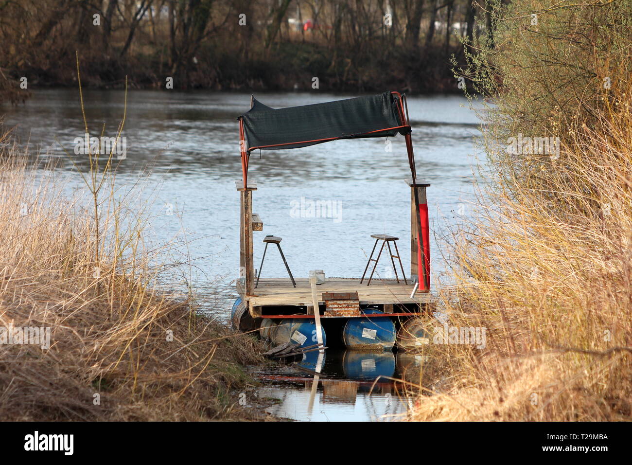 Homemade improvised river barge made of metal barrels and wooden boards ...