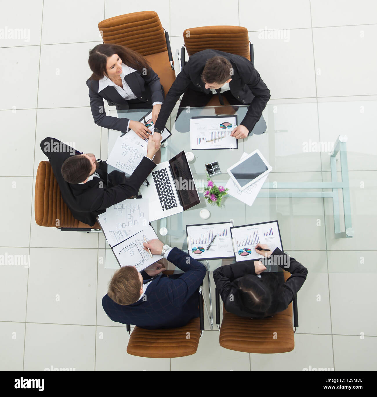 business partners shaking hands after a discussion of the new fiscal ...