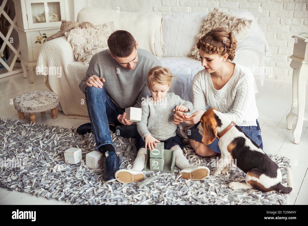 happy family playing with a pet dog in the spacious living room Stock ...