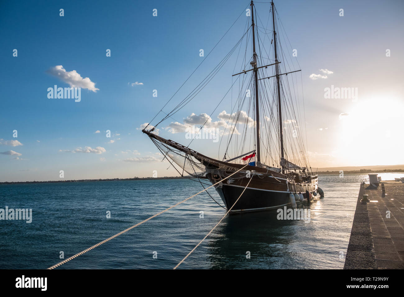 An elegant tall ship among the colorful variety of boats and ships fill ...