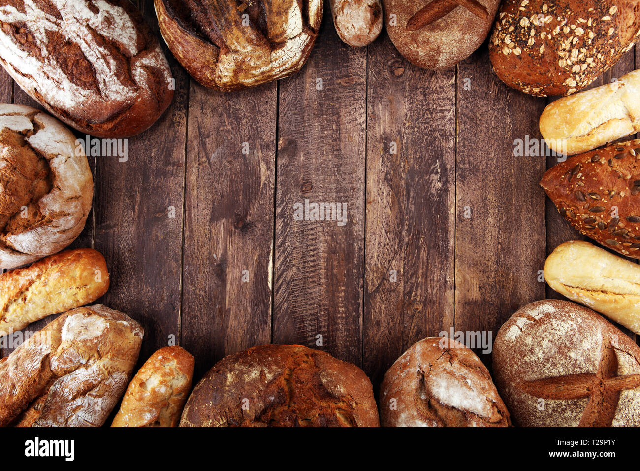 Different kinds of bread and bread rolls on board from above. Kitchen ...