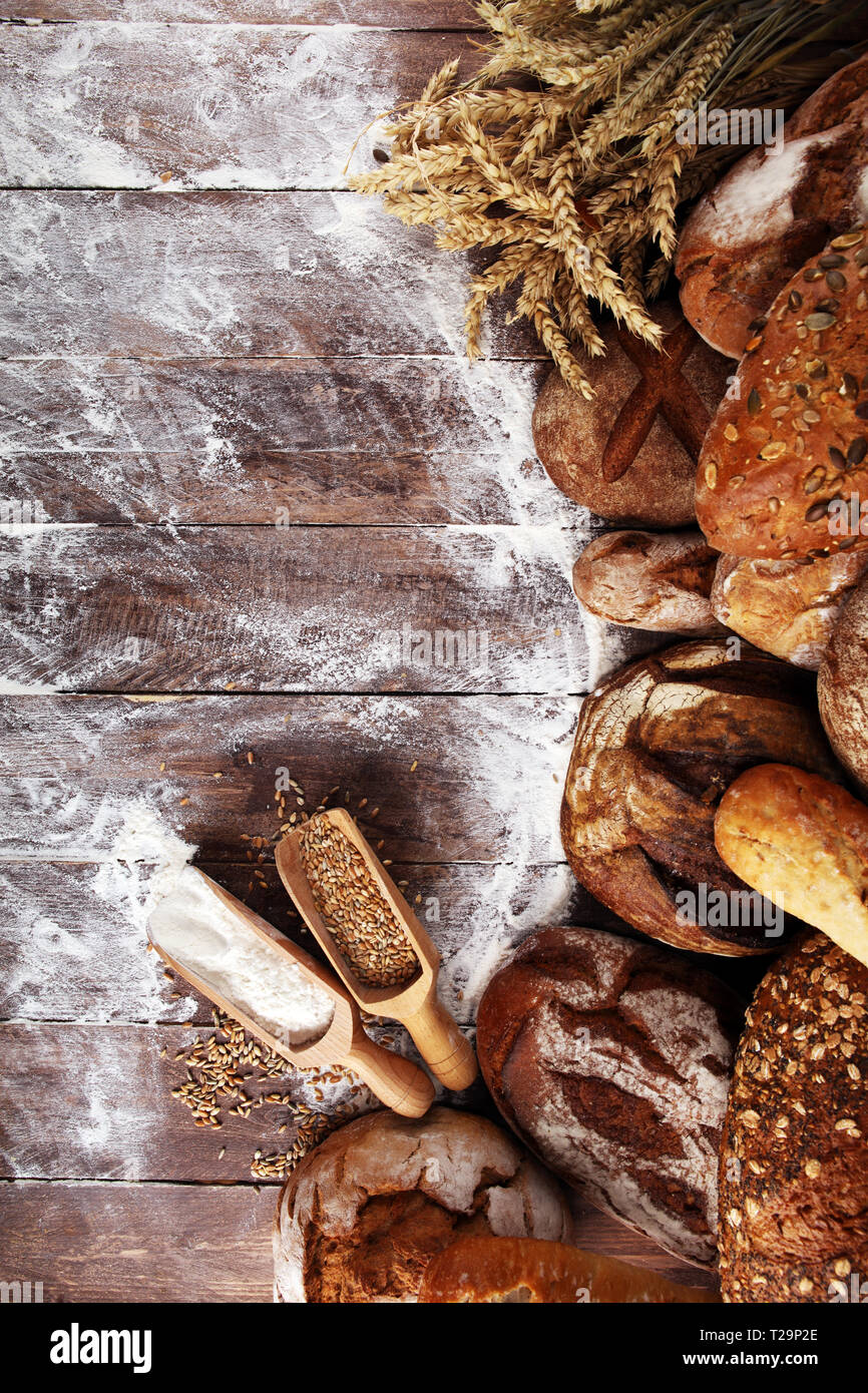 Different kinds of bread and bread rolls on board from above. Kitchen ...