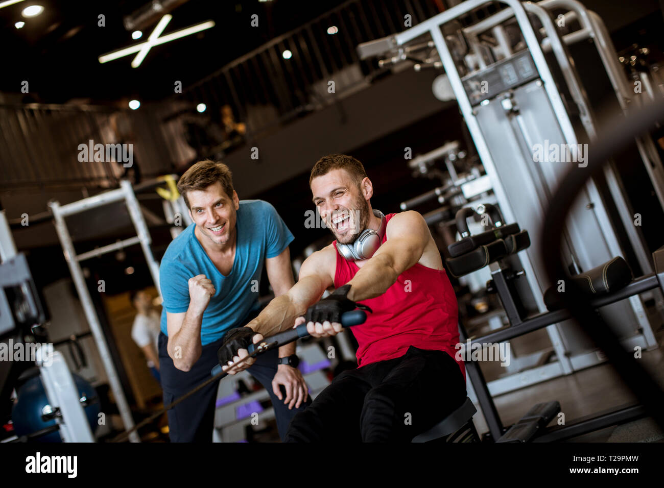 Young man with trainer doing exercise in the modern gym Stock Photo - Alamy