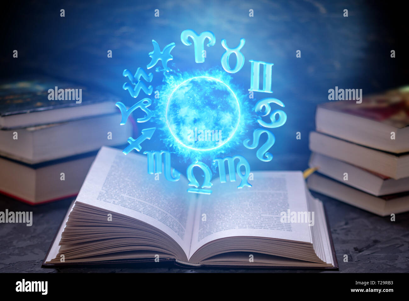 Open book on astrology on a dark background. The glowing magical globe ...