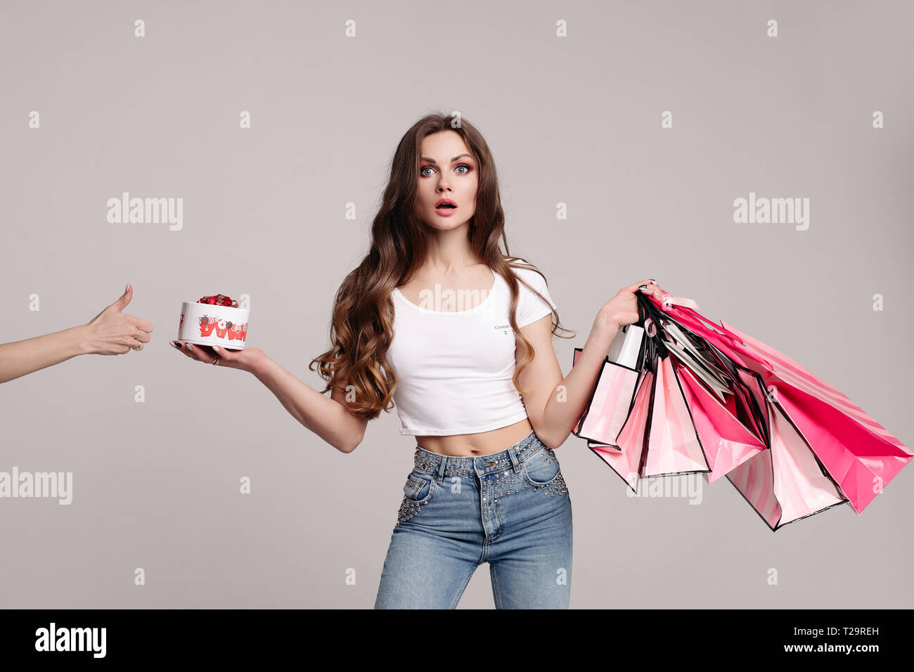 Surprised young brunette girl after hard shopping day. Beautiful model ...