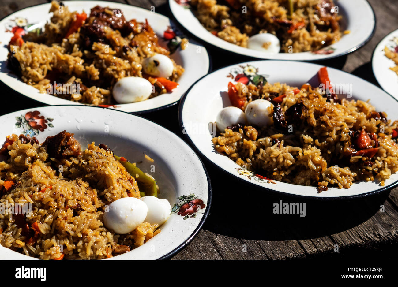 Uzbek pilaf in plates on the table. — Pilaf is made from lamb or beef ...