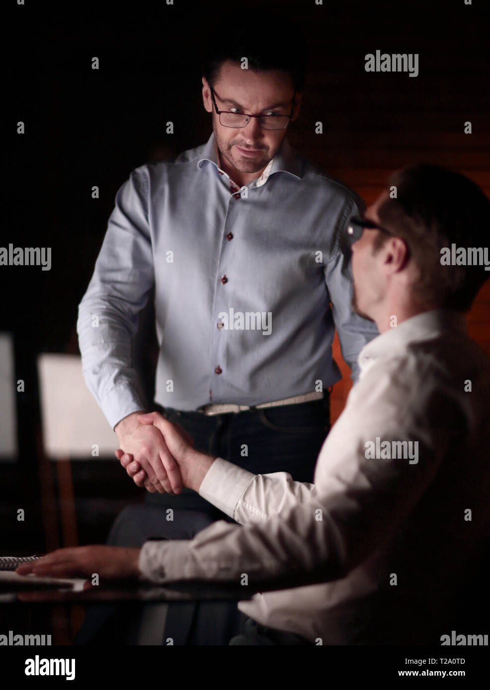 employees shaking hands near the desktop Stock Photo - Alamy