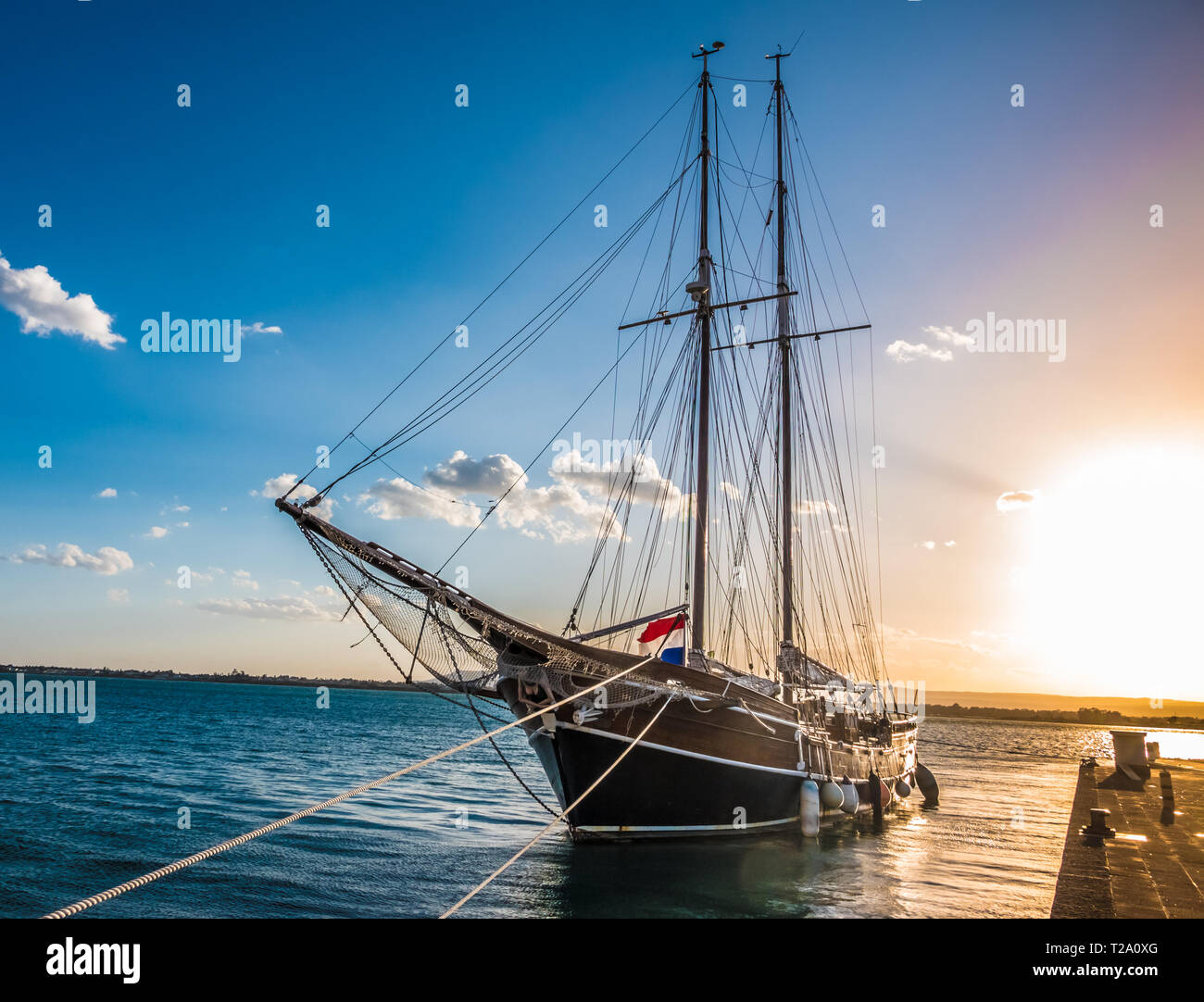 An elegant tall ship among the colorful variety of boats and ships fill ...