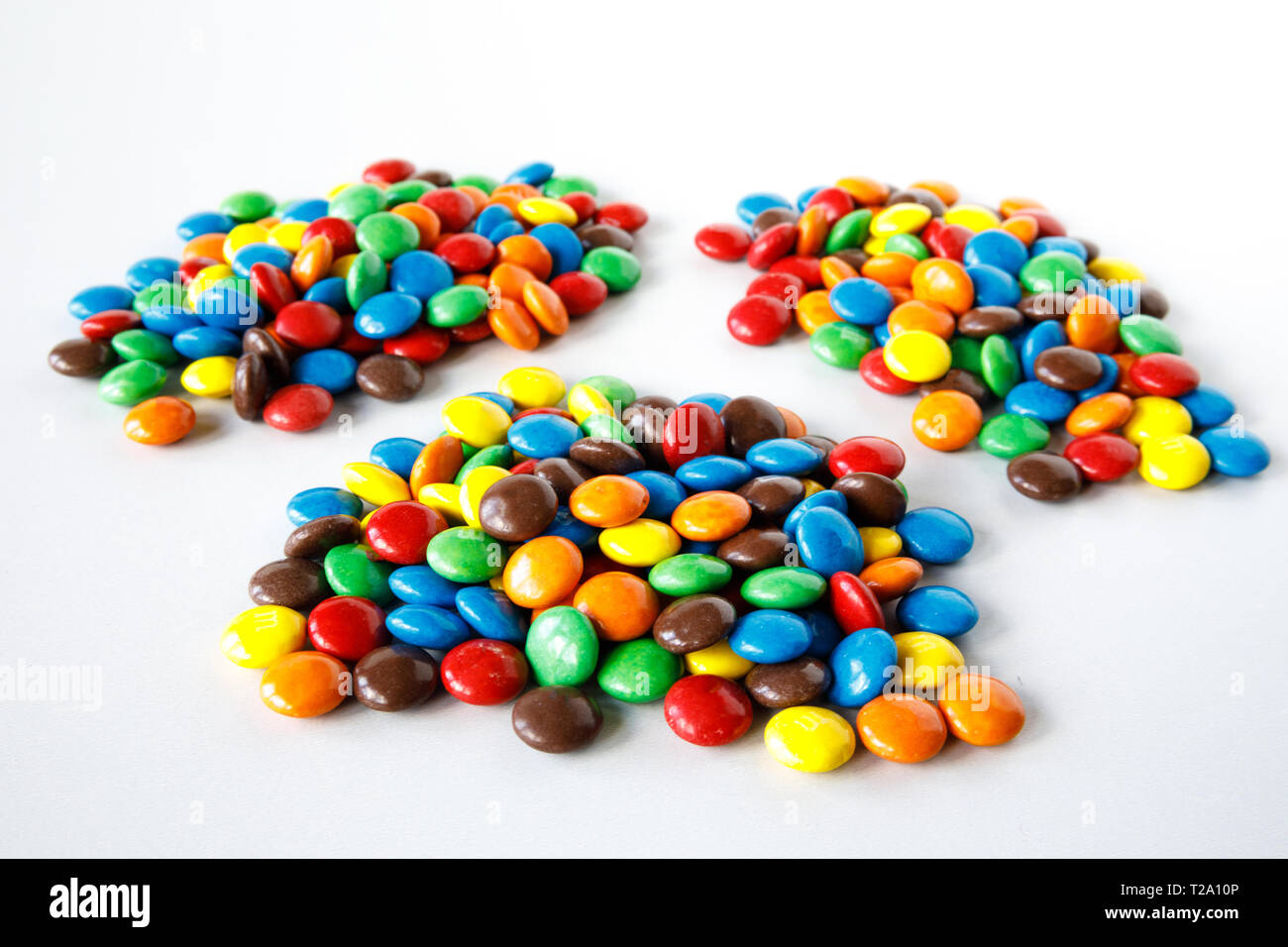 Three piles of colored smarties Stock Photo - Alamy