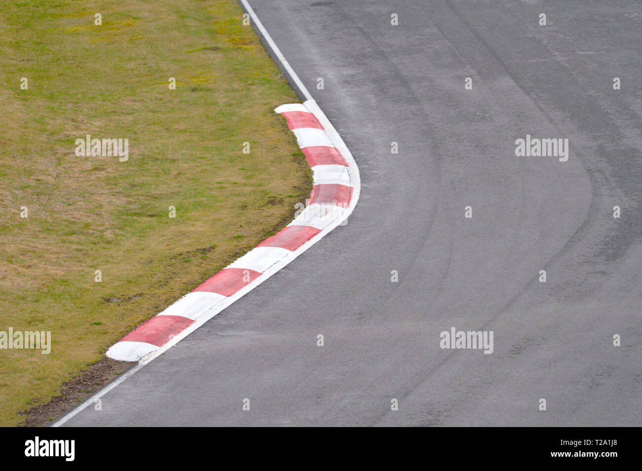 Fast left curve on a race track surrounded with green lawn Stock Photo ...