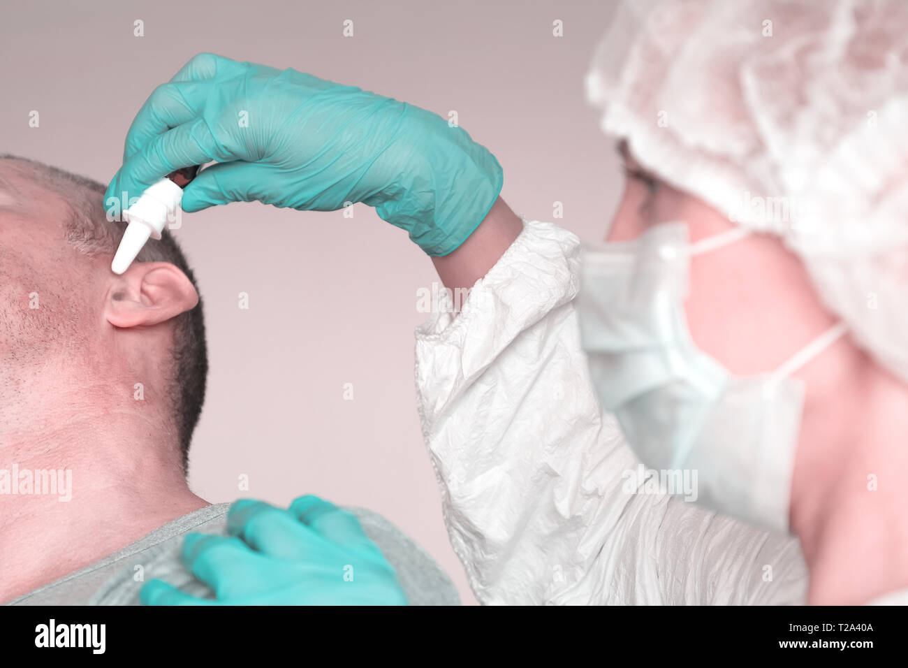 Doctor Otolaryngologist treats the otitis media patient. Buries the ear ...