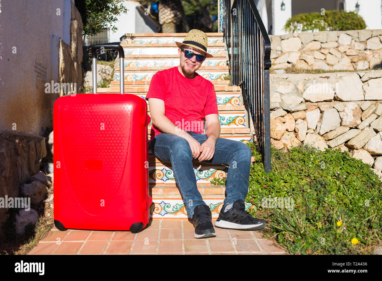 people, travelling and rest concept - young man sitting on stairs near ...